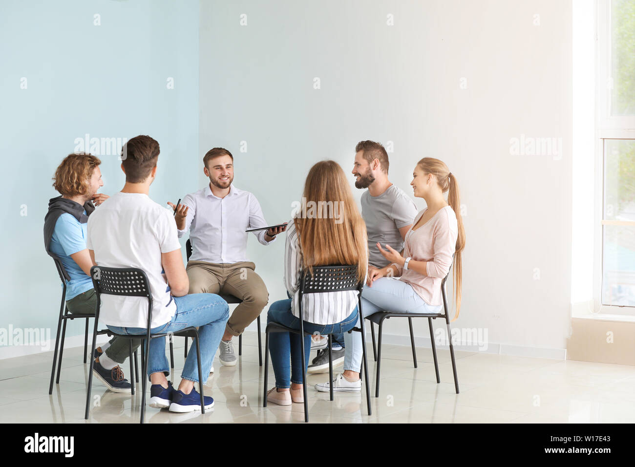 Young people with psychologist at group therapy session Stock Photo - Alamy