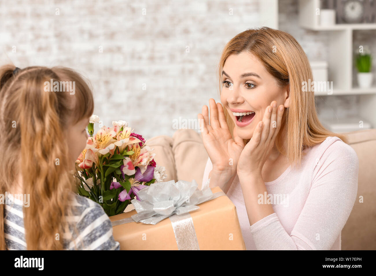 Little girl greeting her mother at home Stock Photo - Alamy