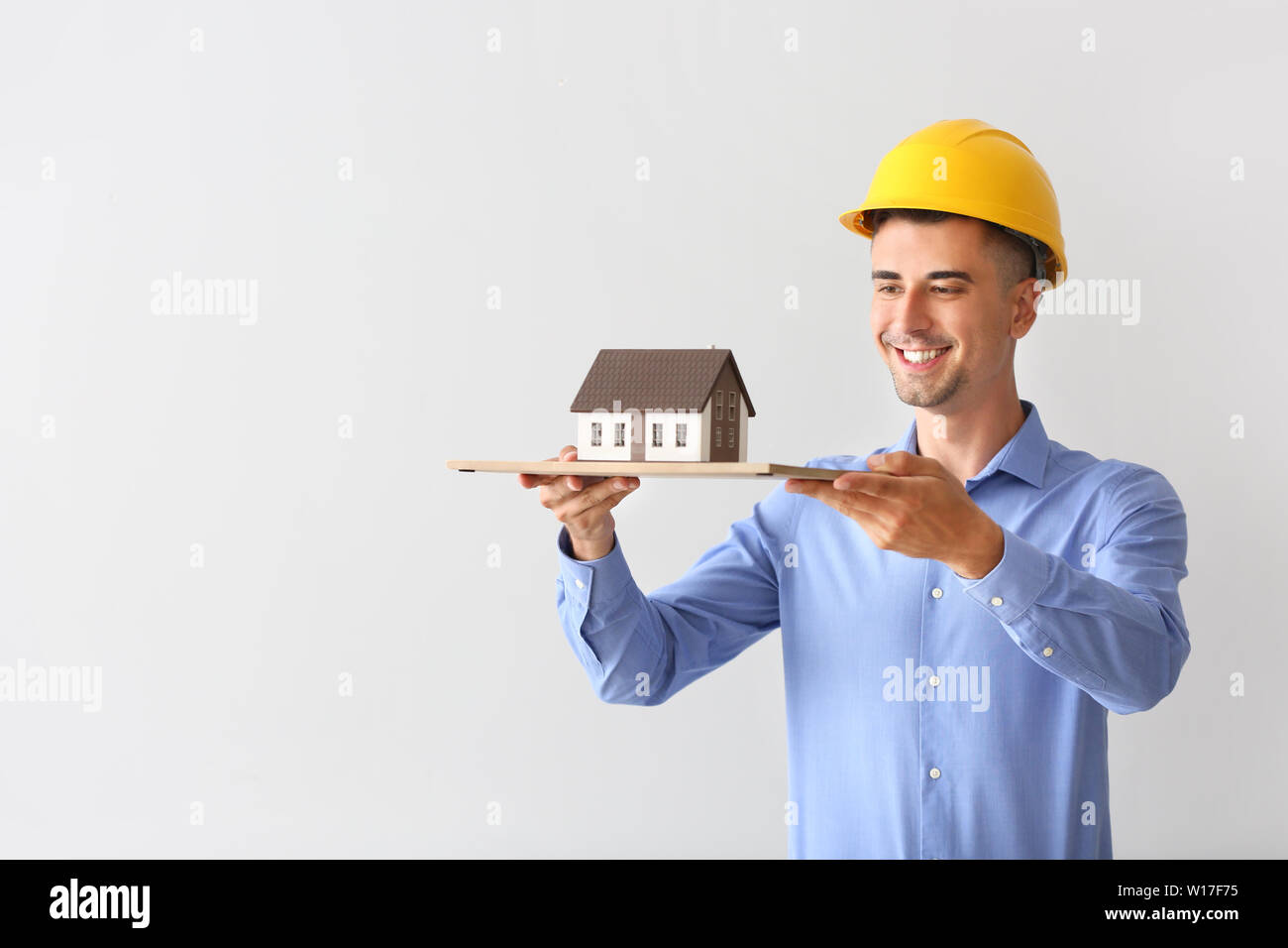 Handsome male architect with model of house on white background Stock ...