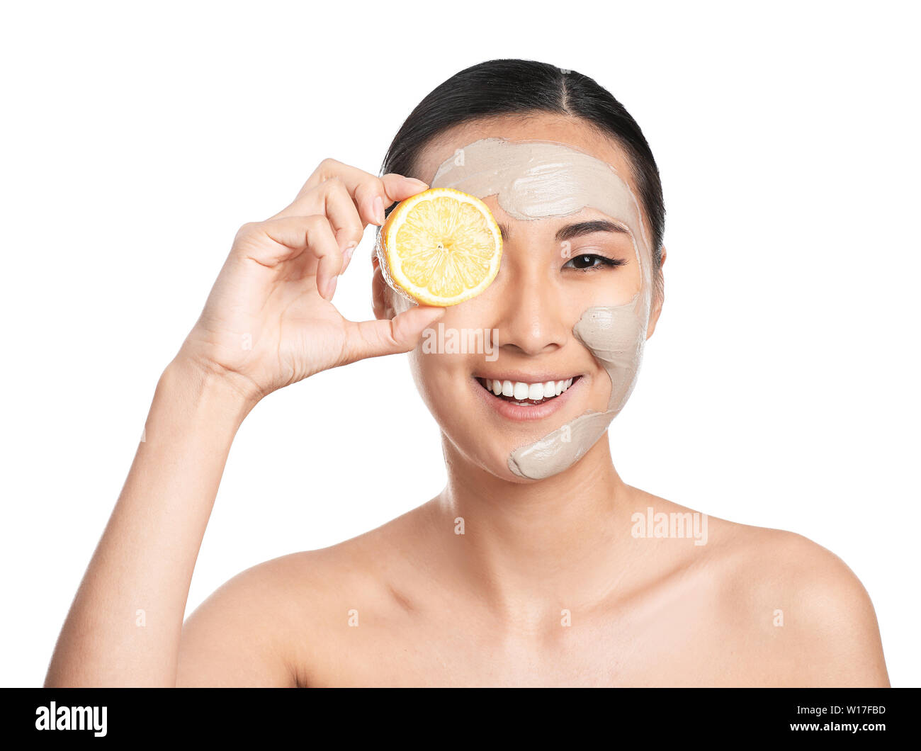 Beautiful Asian woman with facial mask and lemon on white background ...