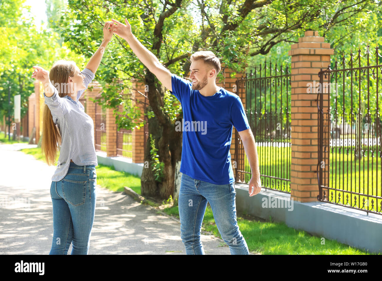 Happy young couple dancing in park on summer day Stock Photo - Alamy
