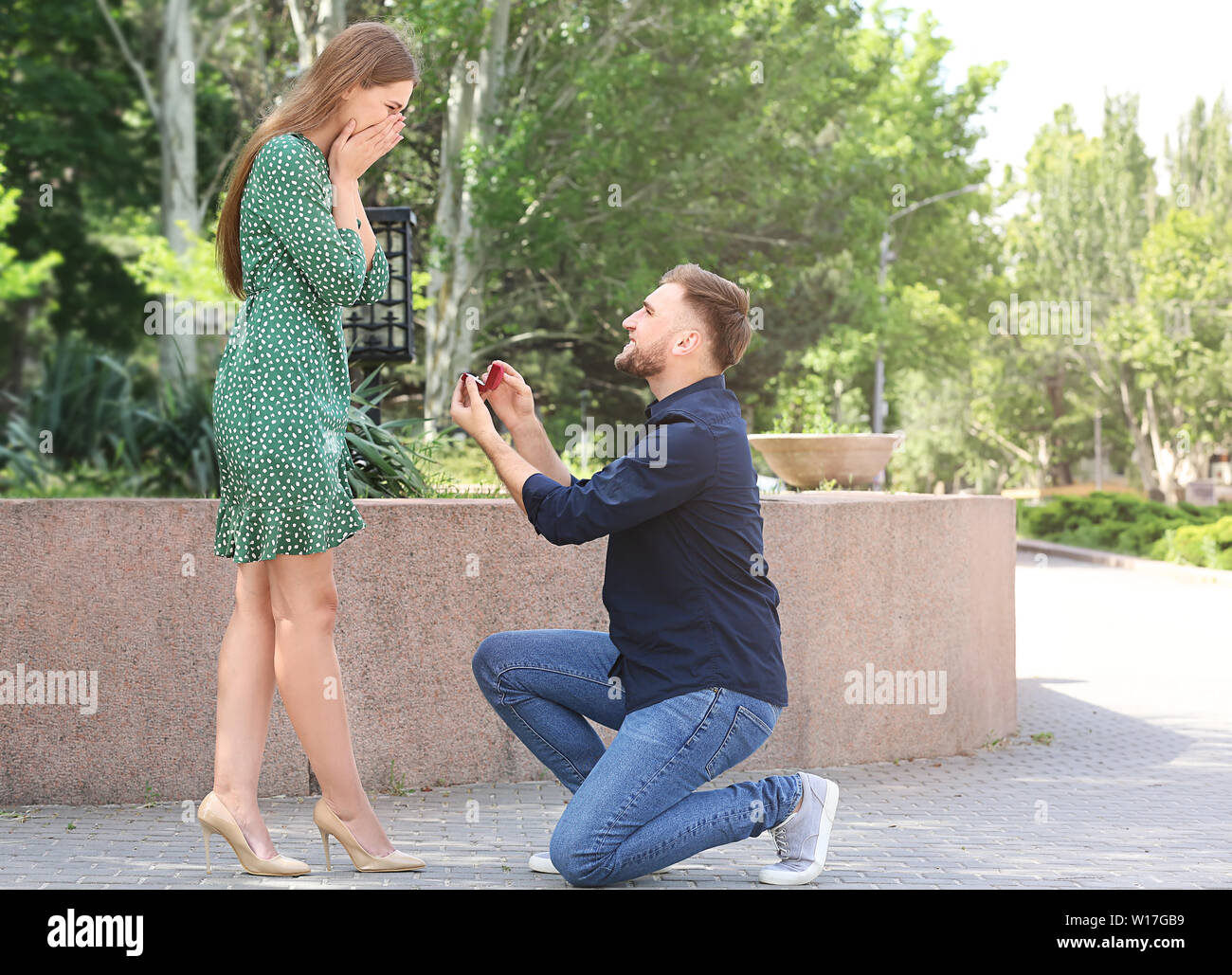 Young man proposing to his beloved in park Stock Photo - Alamy