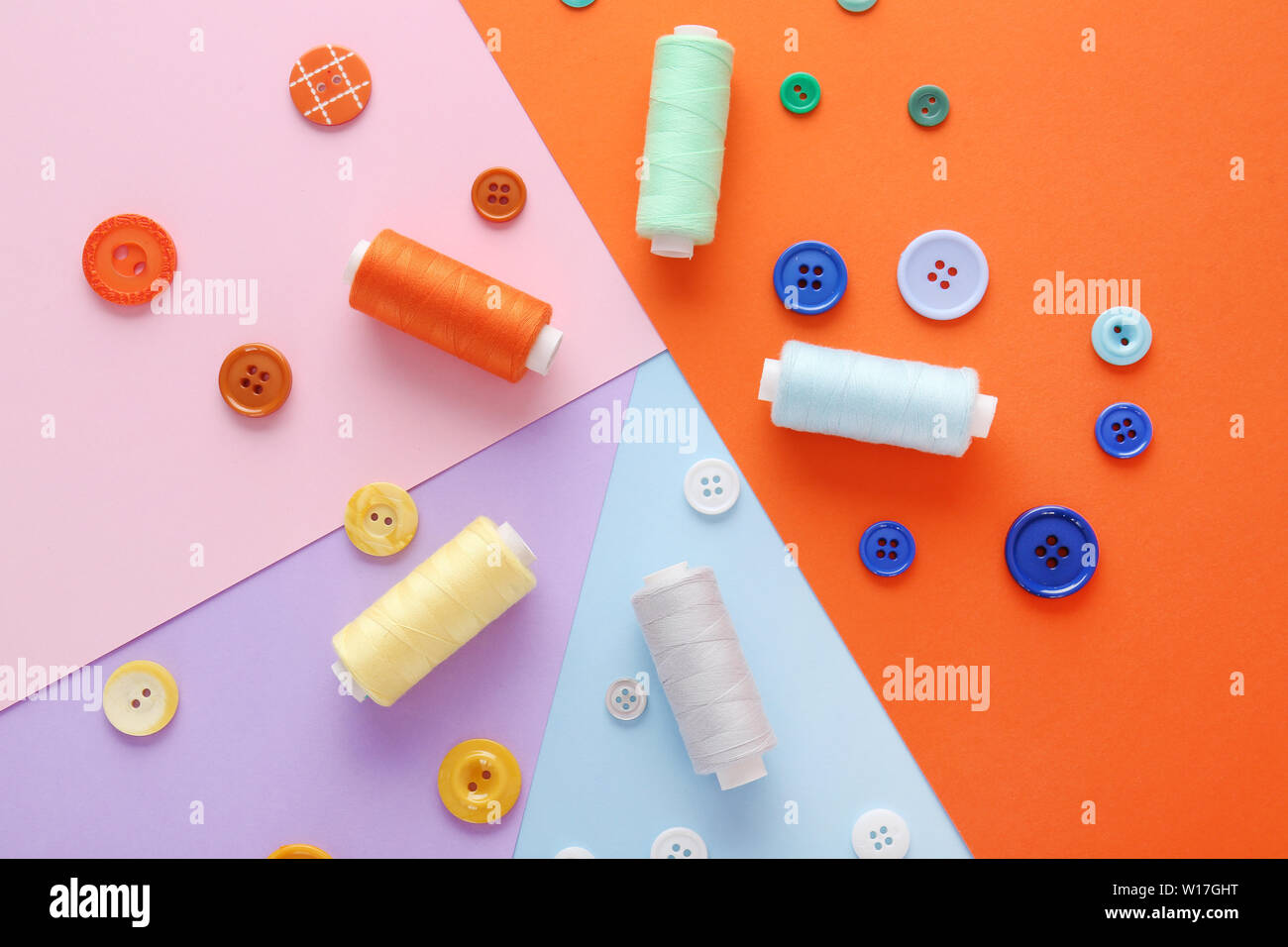 Set of sewing threads and buttons on color background Stock Photo - Alamy