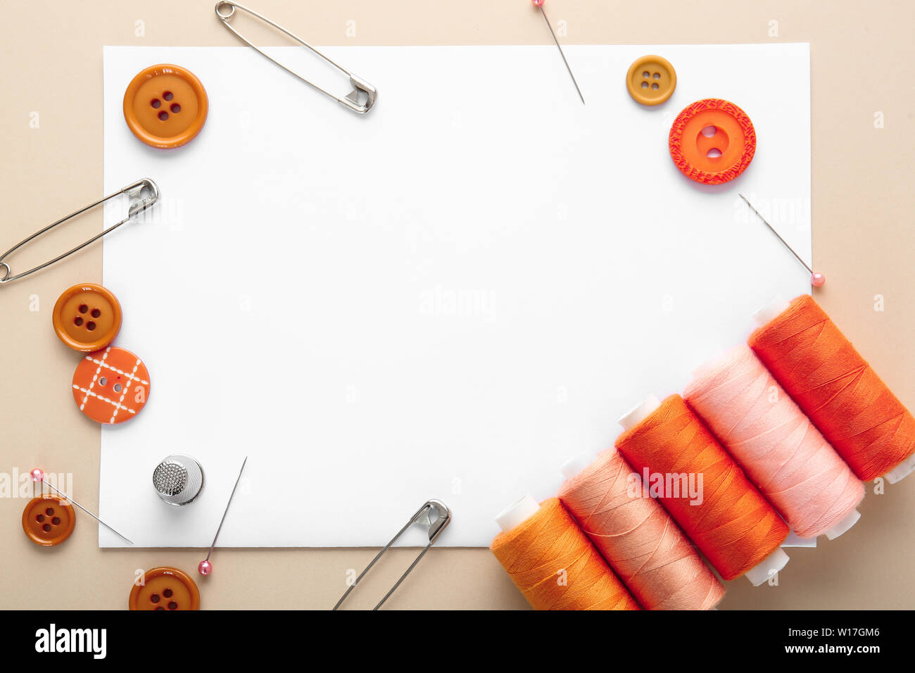 Set of sewing threads with accessories and sheet of paper on color ...