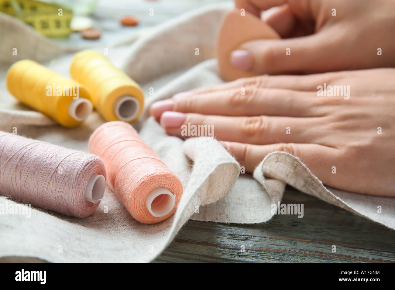 Female tailor with fabric and sewing threads, closeup Stock Photo - Alamy