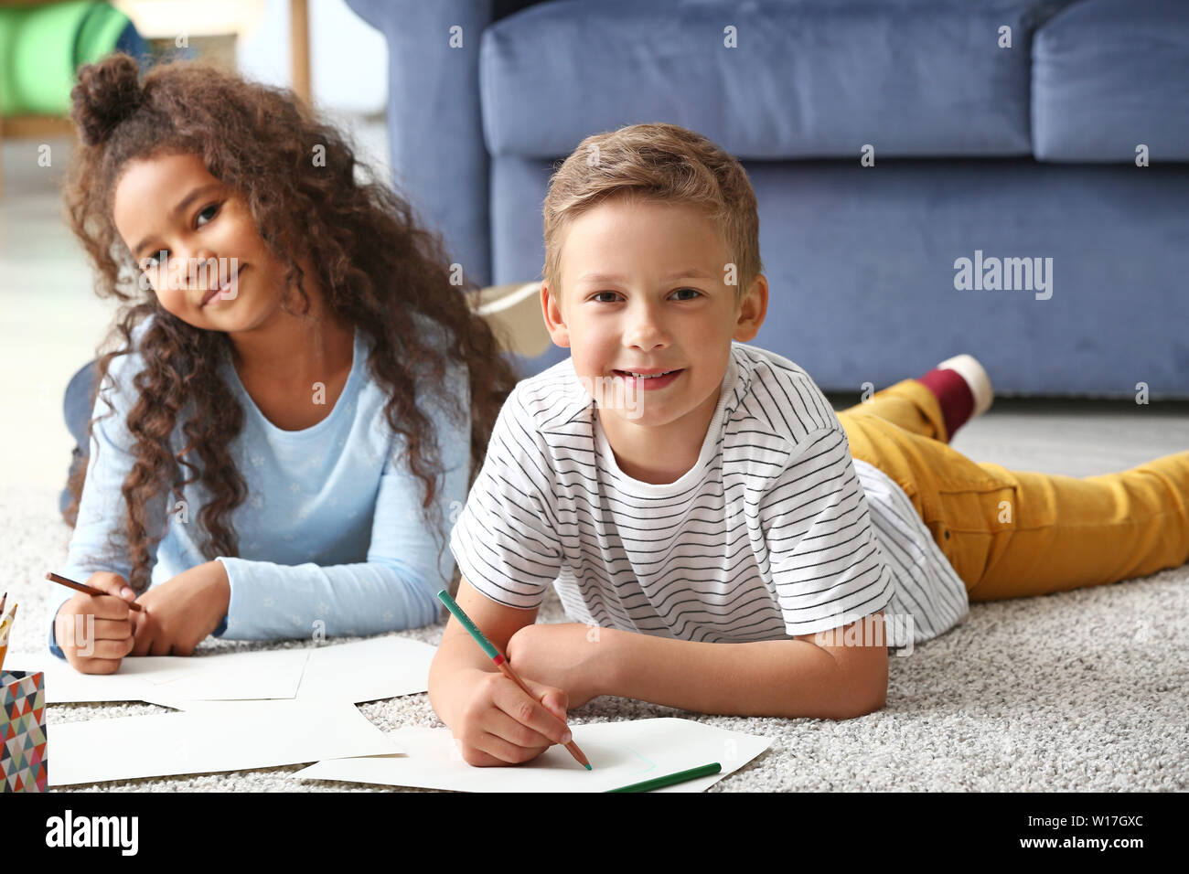 Happy adopted children drawing pictures in their new home Stock Photo ...