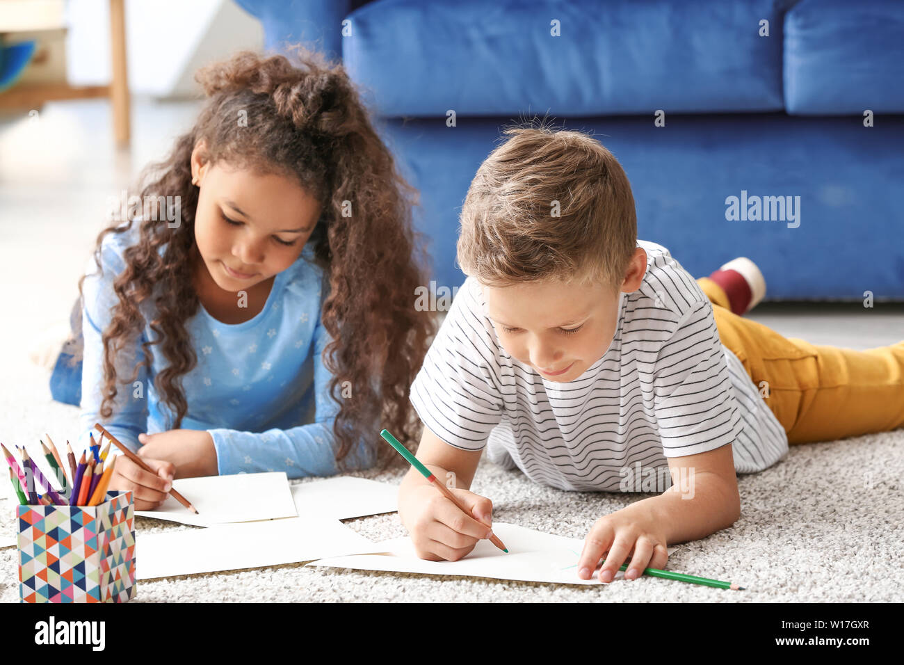 Happy adopted children drawing pictures in their new home Stock Photo ...