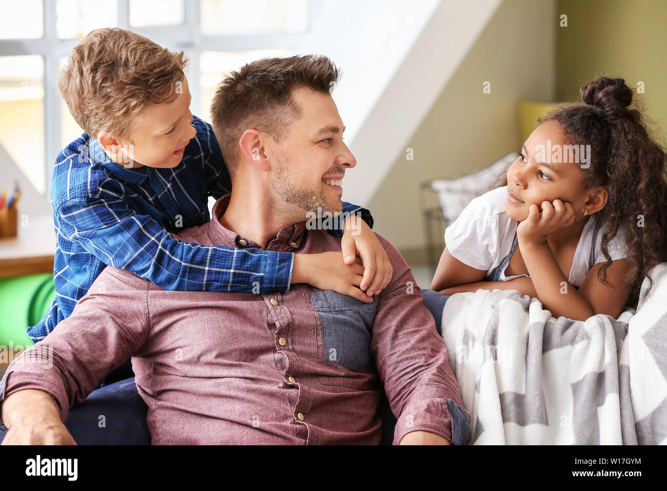 Happy man with little adopted children at home Stock Photo - Alamy
