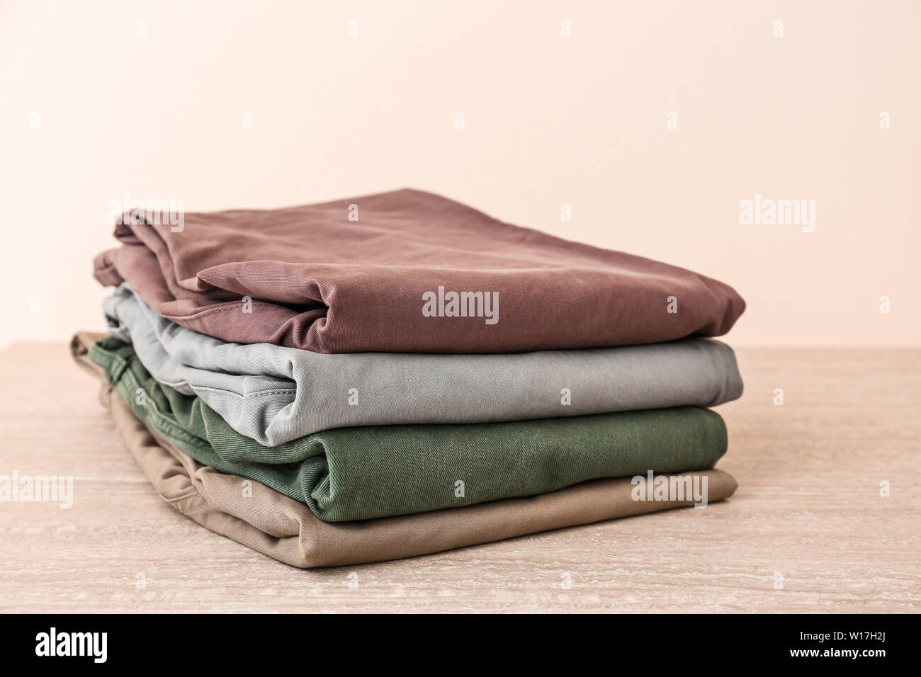 Stack of clean clothes on table against light background Stock Photo ...