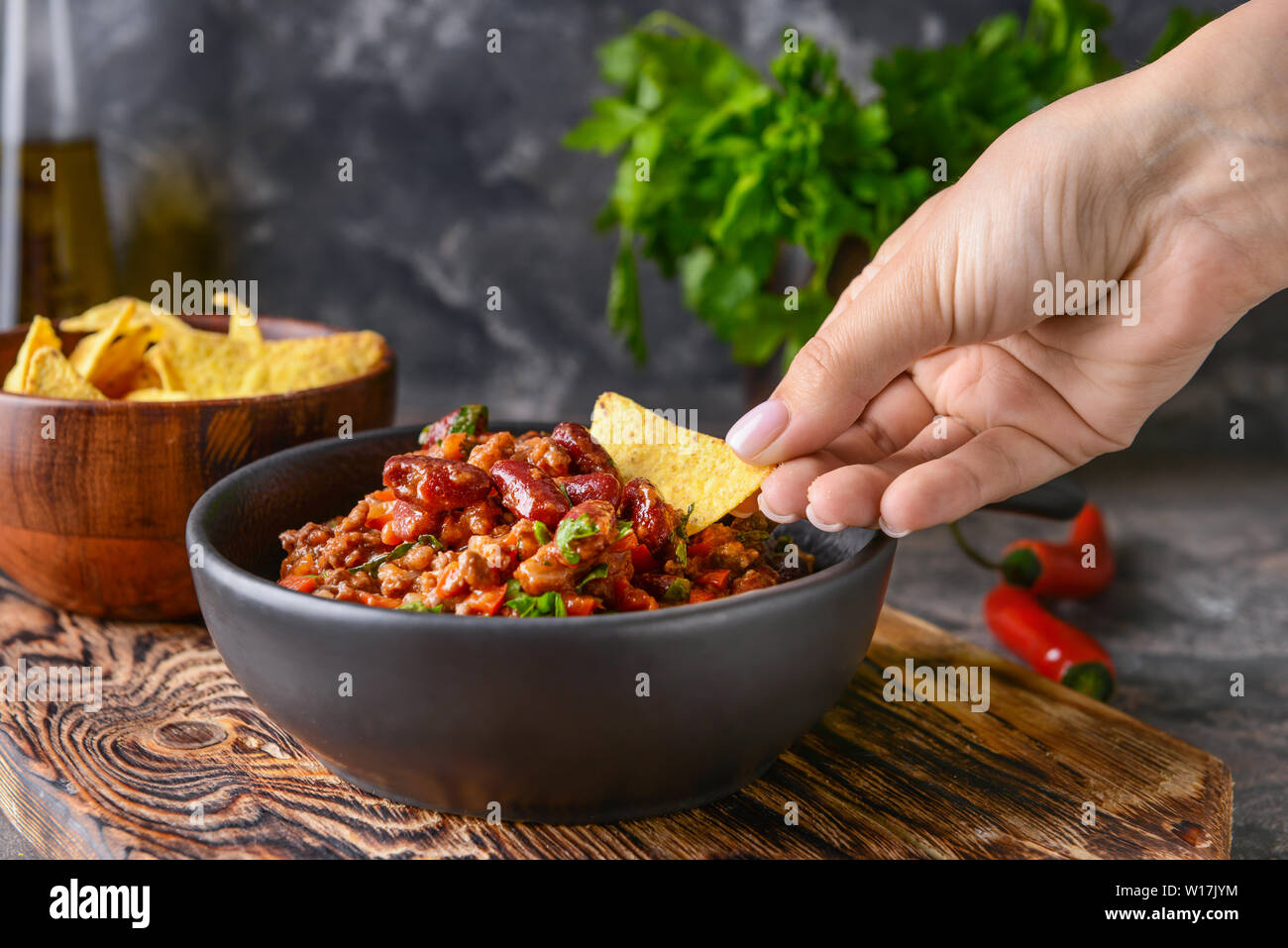Woman eating tasty chili con carne with nachos Stock Photo - Alamy
