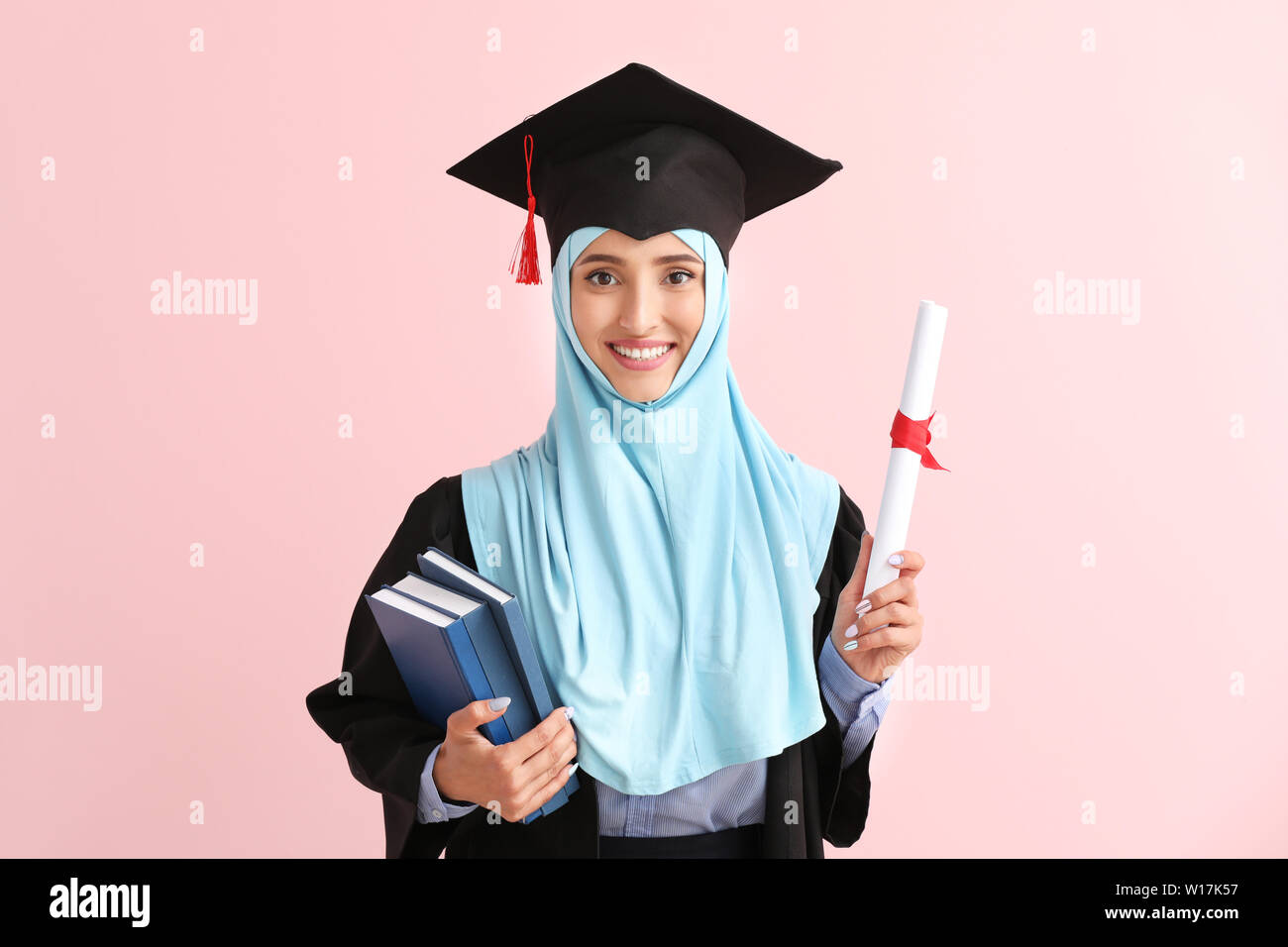 Muslim female graduate with diploma on color background Stock Photo - Alamy