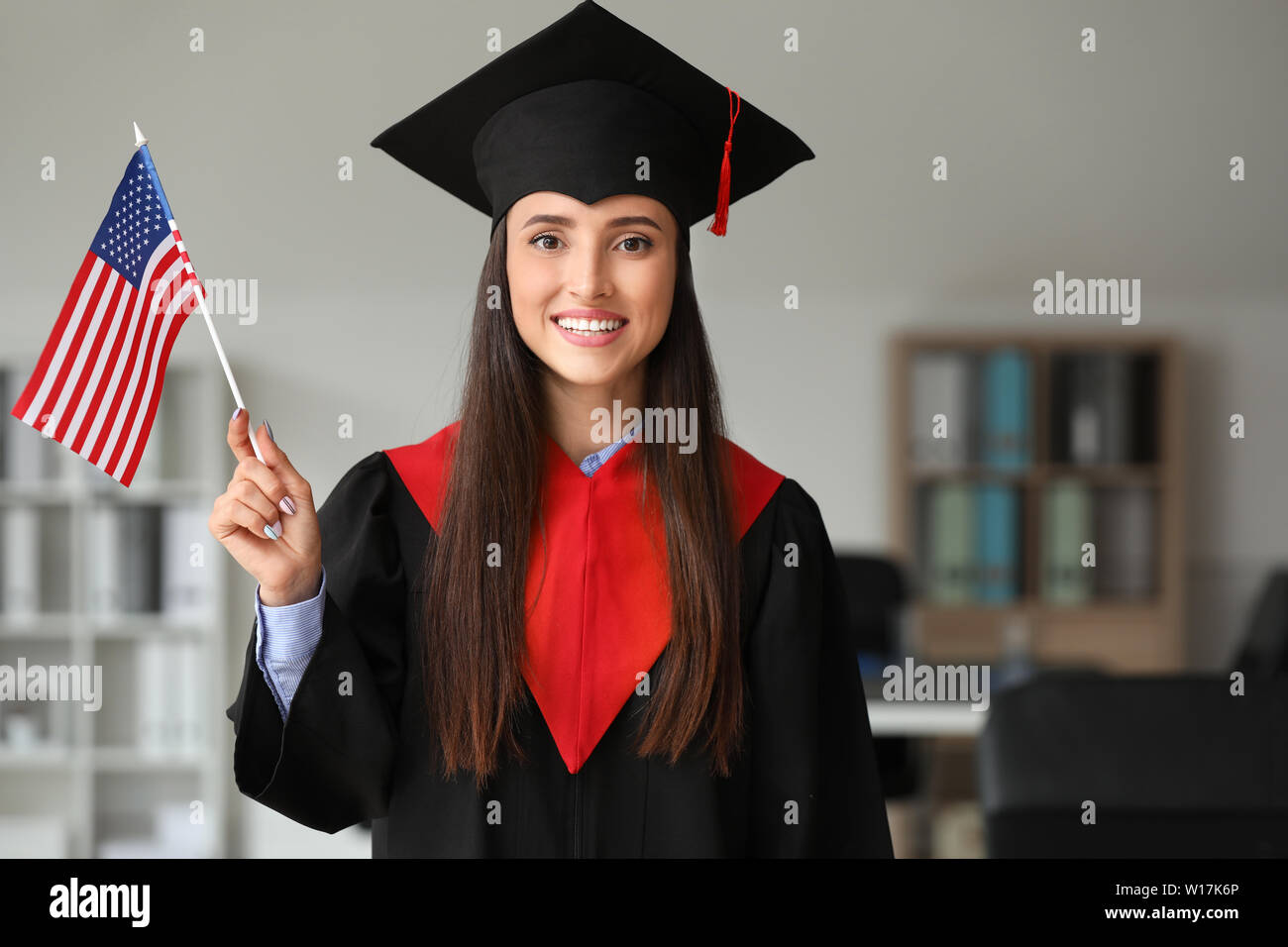Female graduate with USA flag at the university Stock Photo - Alamy