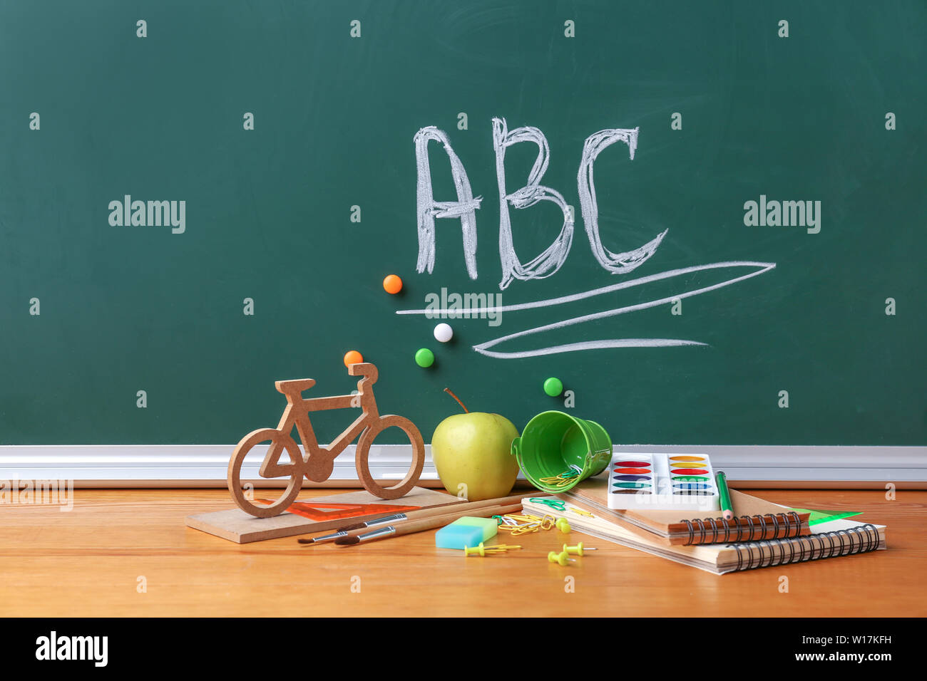 Set of school supplies on table in classroom Stock Photo - Alamy