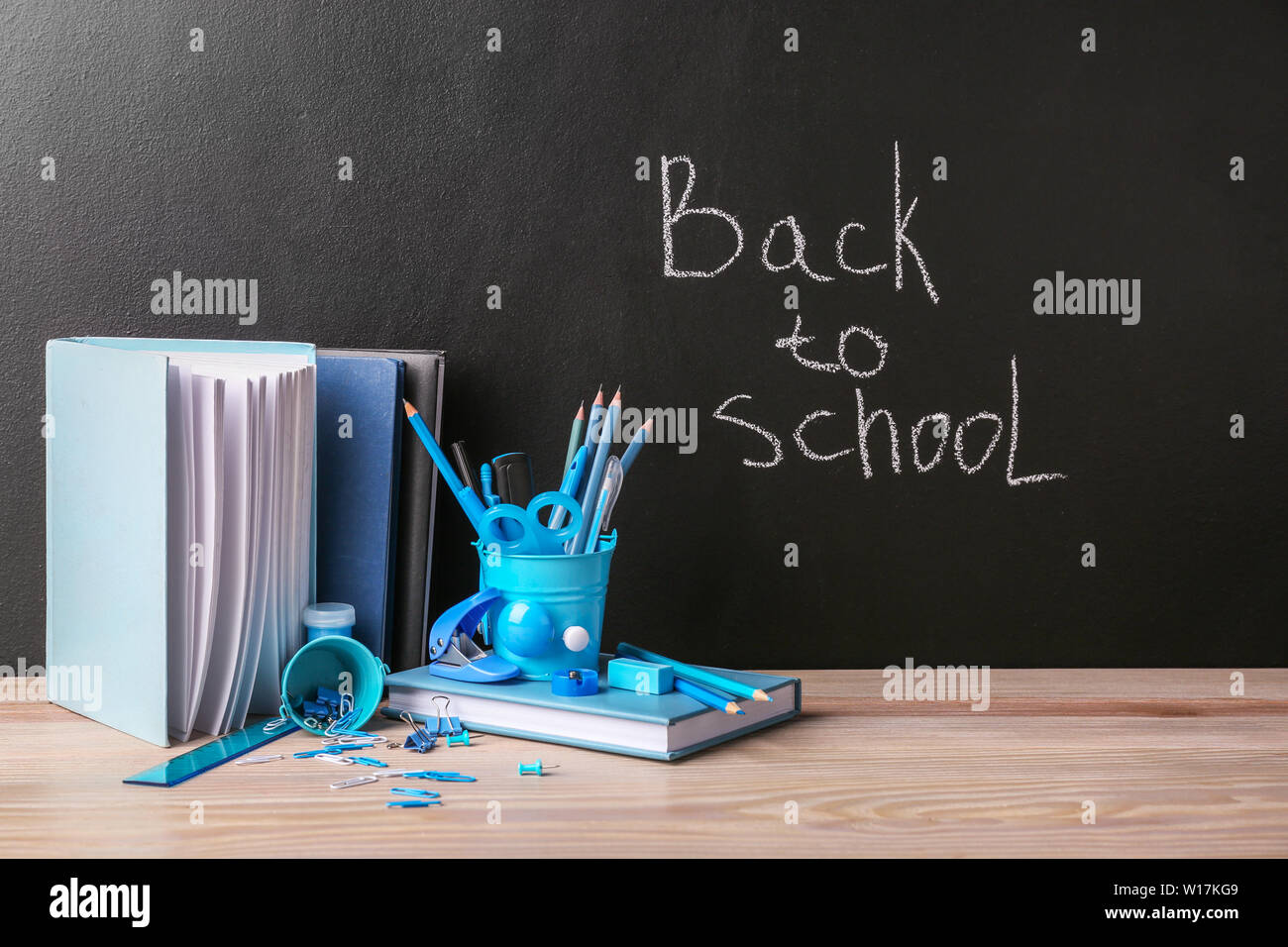 Set of school supplies on table in classroom Stock Photo - Alamy