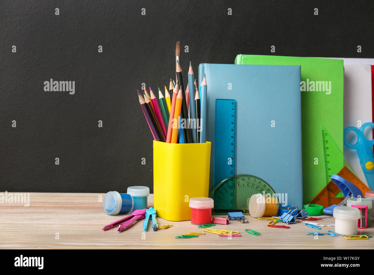 Set of school supplies on table in classroom Stock Photo - Alamy