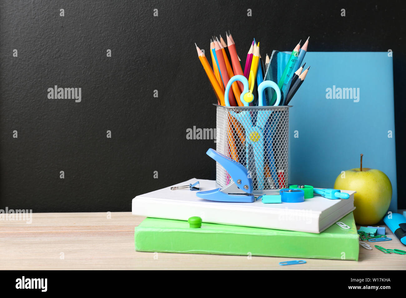 Set of school supplies on table in classroom Stock Photo - Alamy
