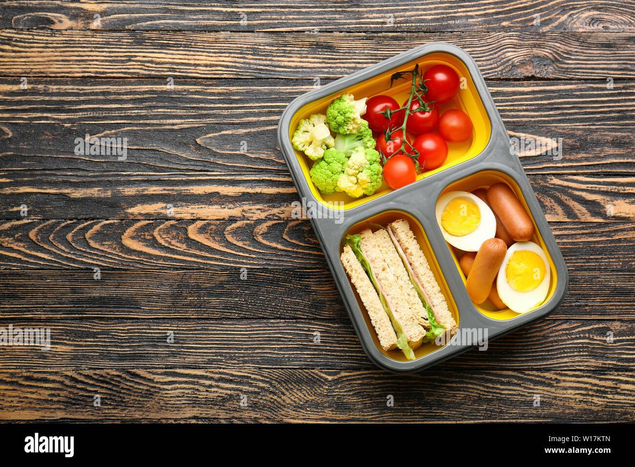 Lunch box with tasty food on wooden background Stock Photo - Alamy