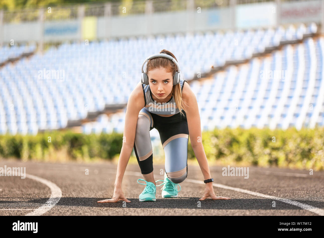 Sporty young woman in crouch start position at the stadium Stock Photo ...