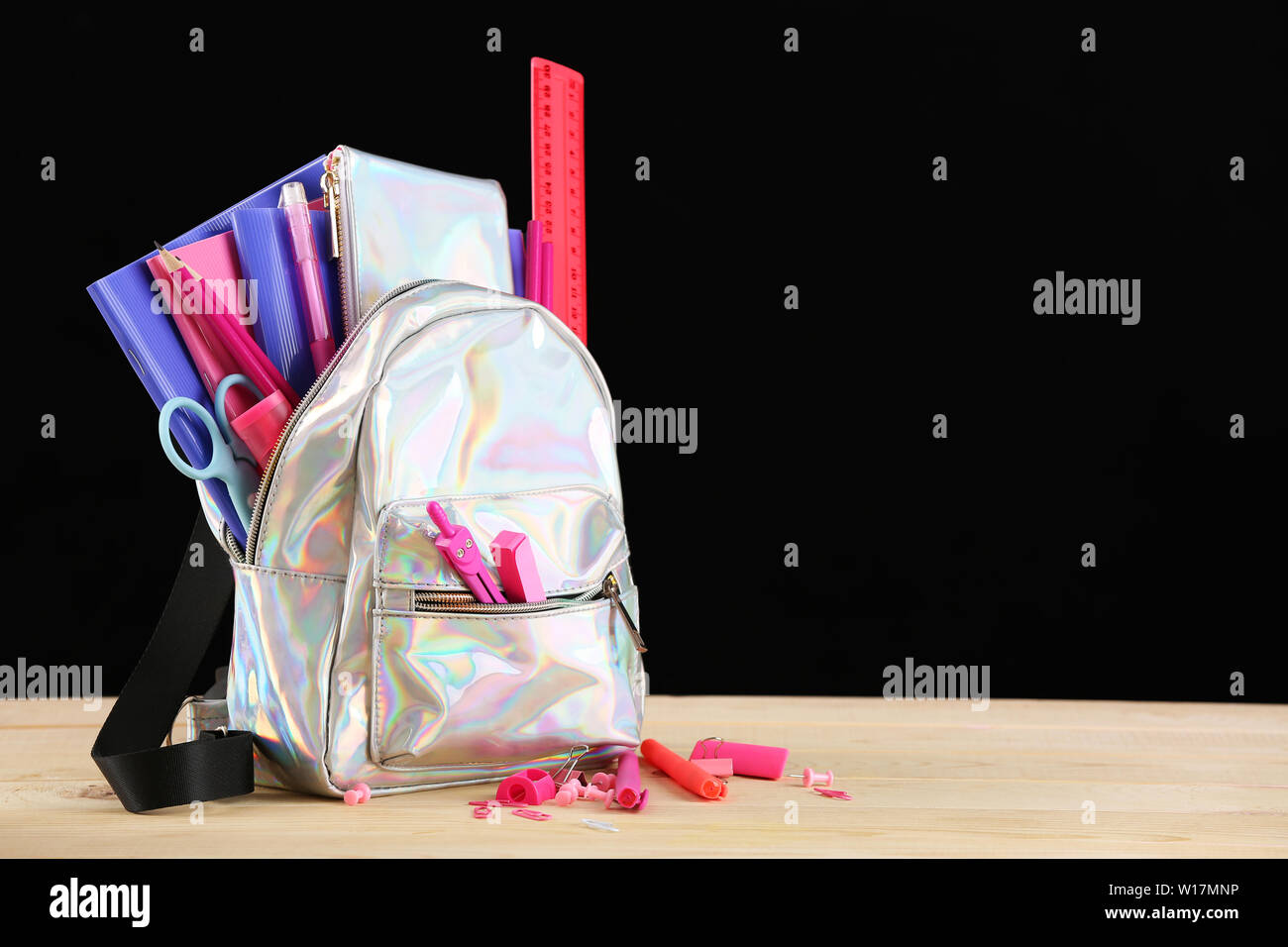 School backpack with stationery on table in classroom Stock Photo - Alamy