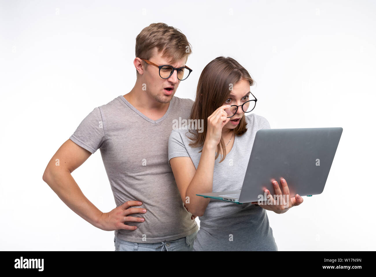 Nerds, study, people concept - a couple of students look at the netbook ...