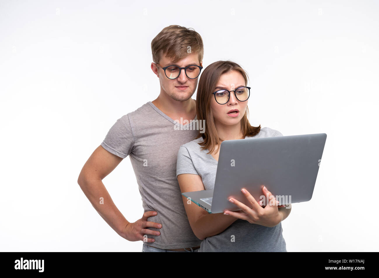 Nerds, study, people concept - a couple of students look at the netbook ...