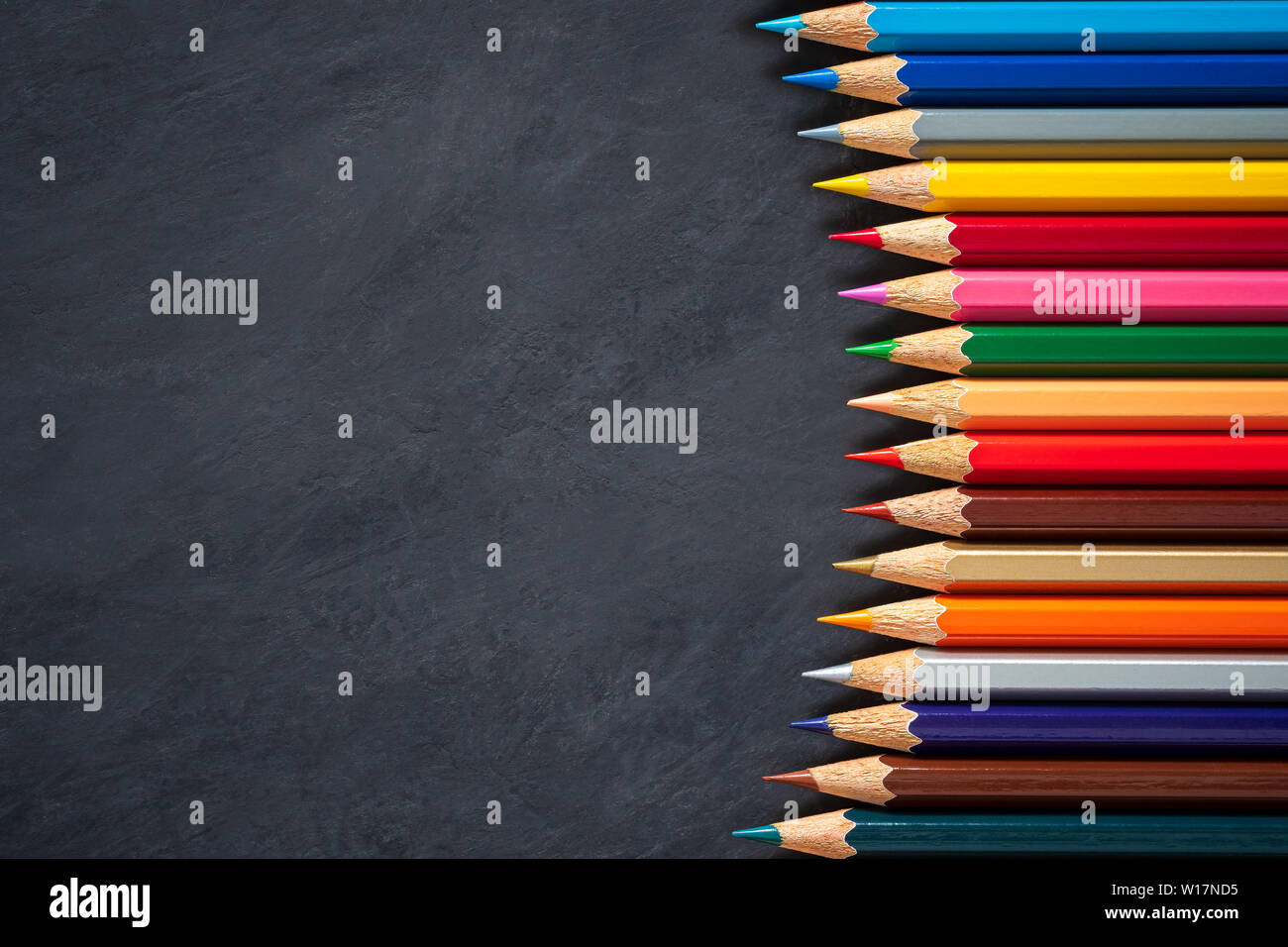 Colored pencils on chalkboard background. Top view and copy space ...