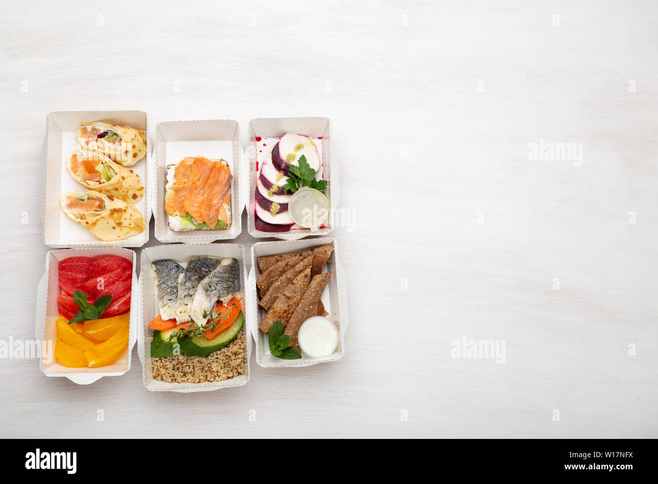 Set of healthy meals for the day in lunch boxes stands on a white table ...
