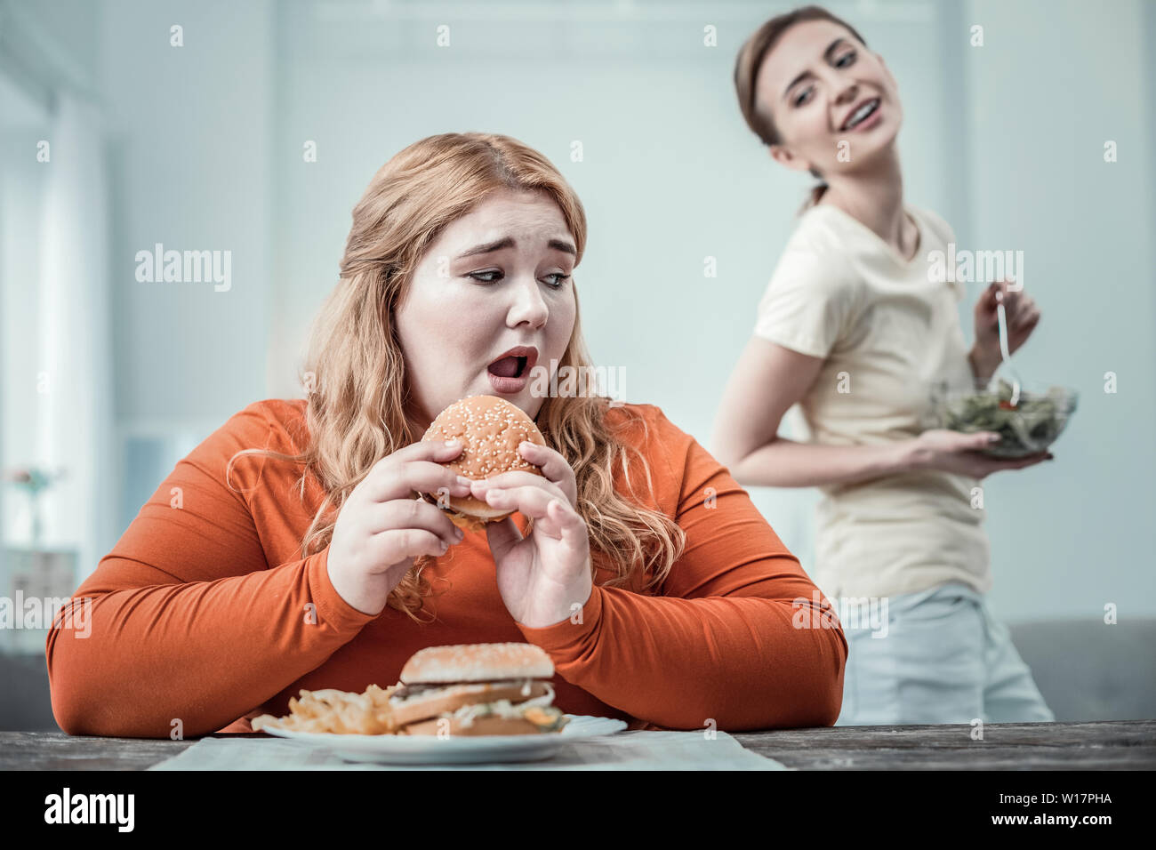 Positive delighted slim female laughing at her friend Stock Photo - Alamy