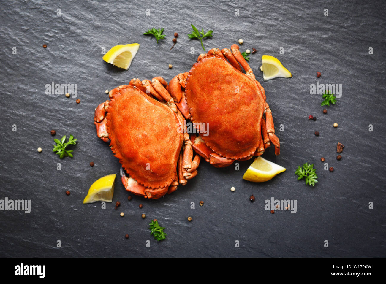 Crabs cooked with lemon on plate served on dark plate top view / stone ...