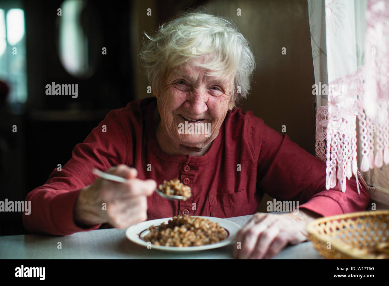 The old woman laughs at dinner at the table in the house Stock Photo ...