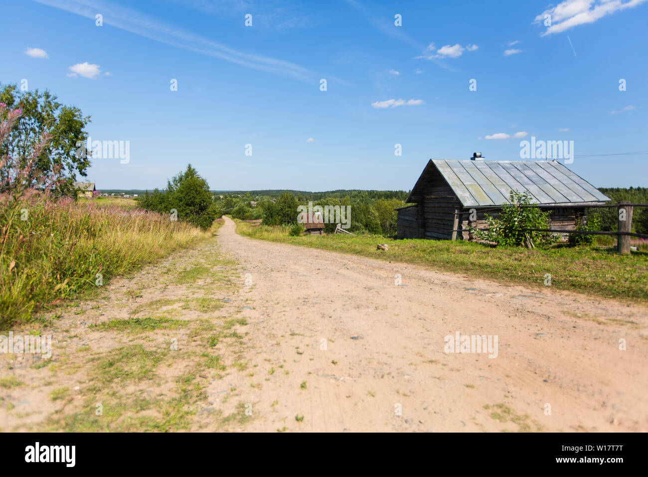 Wooden house and country road, rural landscape. Remote village in ...