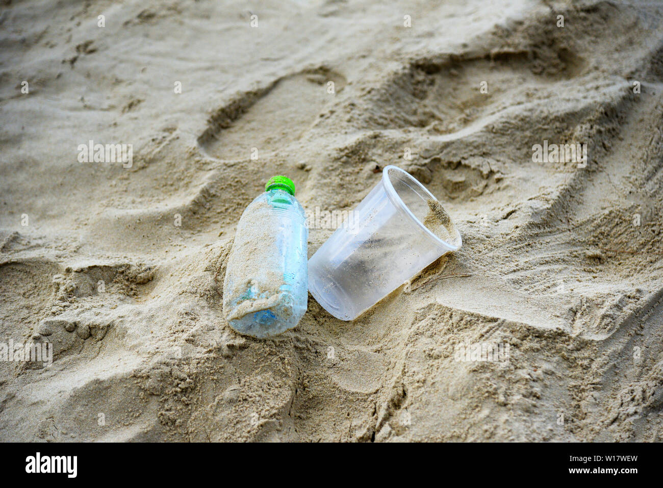 Garbage in the sea with plastic bottle , plastic cup on beach sandy ...