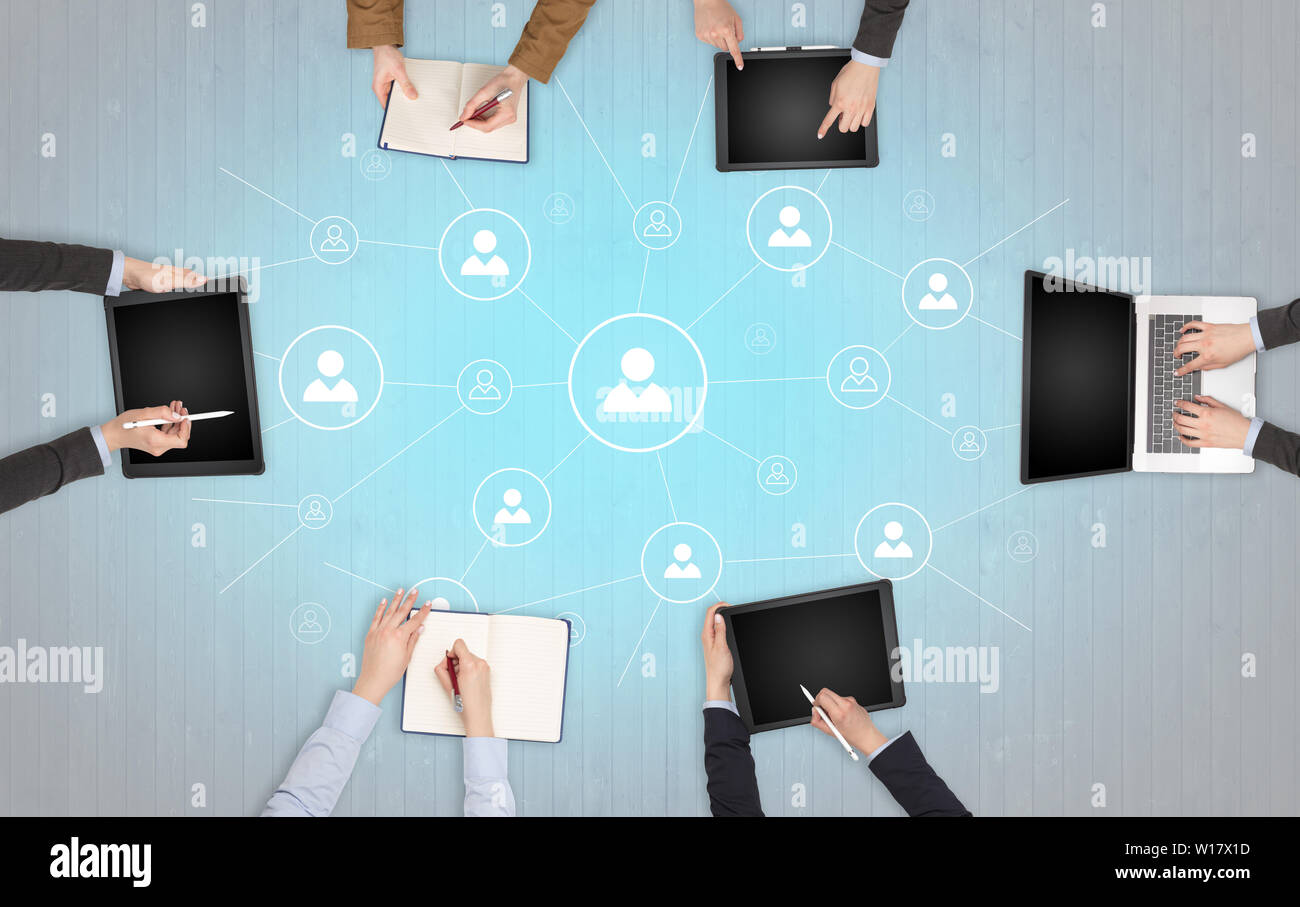 Group of people with devices in hands working in team on tablets ...