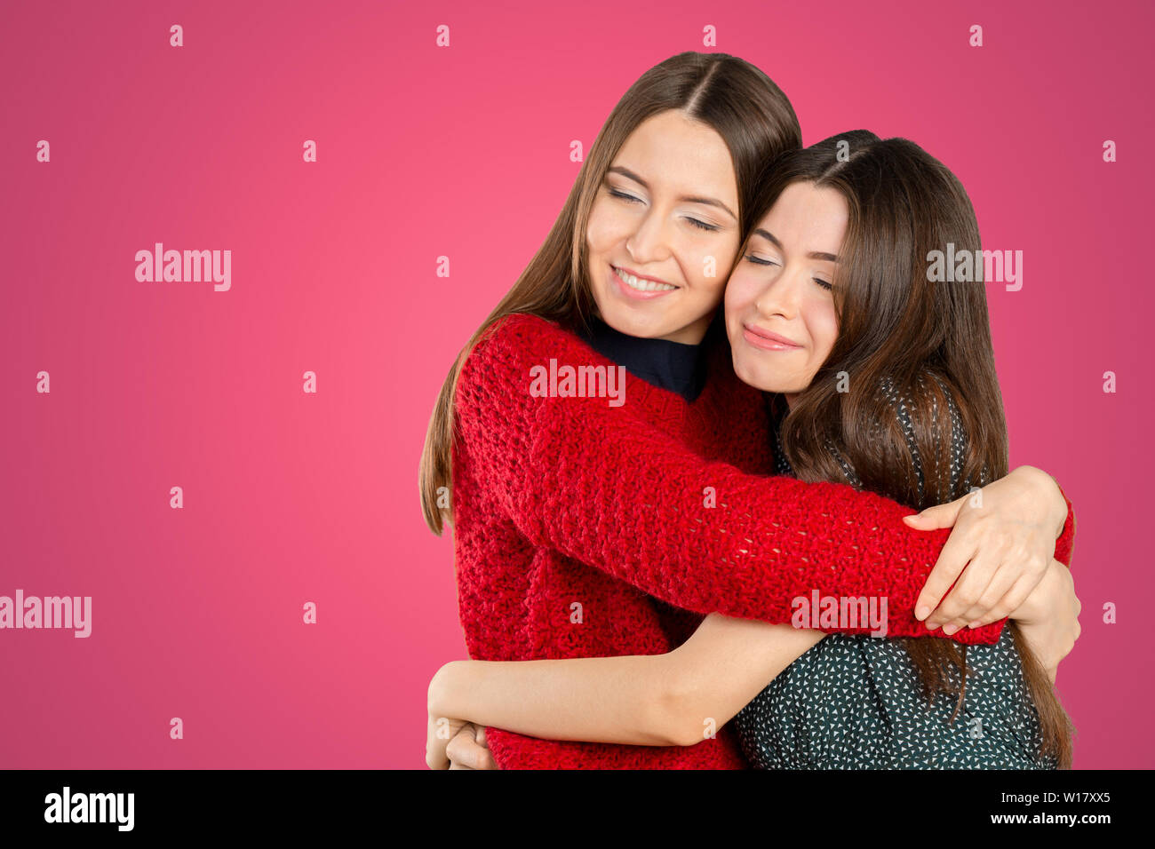Two beautiful sisters hugging each other and smiling Stock Photo - Alamy