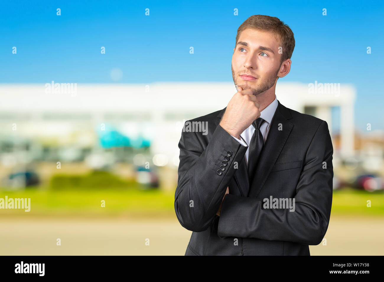 Confused young businessman thinking Stock Photo - Alamy