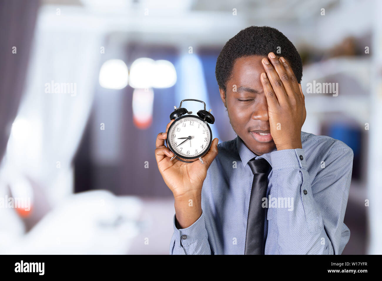 black man holding an alarm clock Stock Photo - Alamy