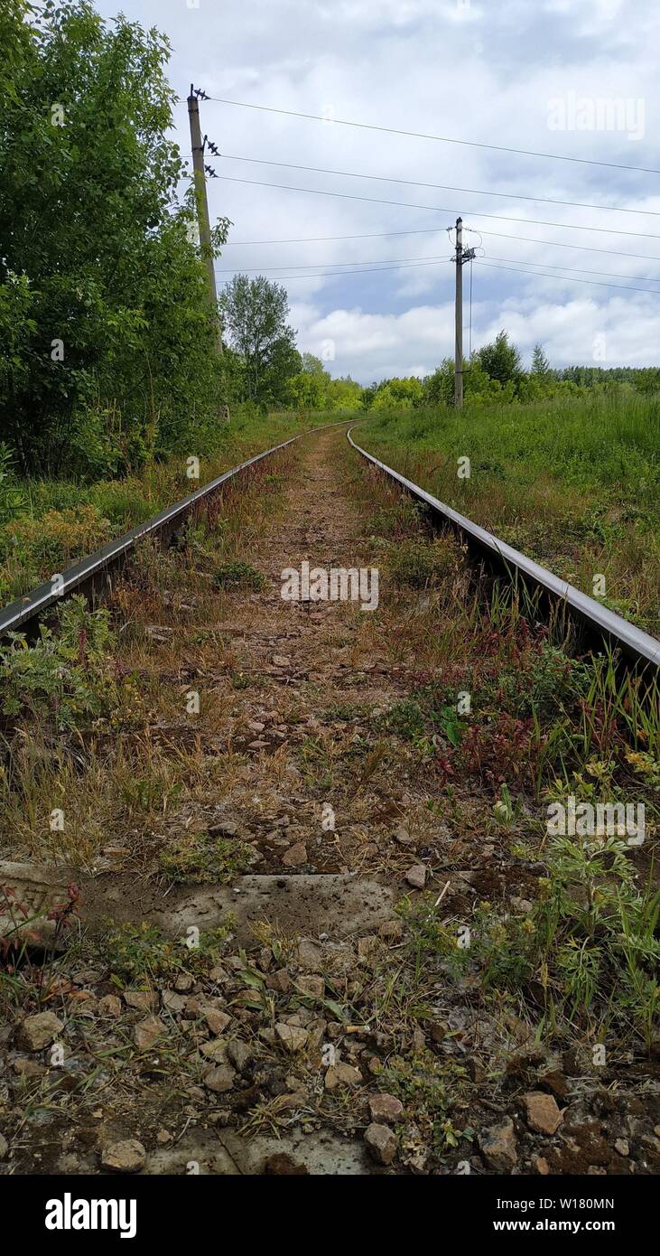 Fragment of an old railway line running along the field at the edge of ...