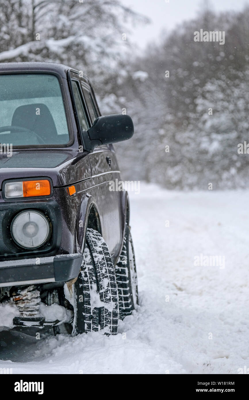 Wheels off-road car on a snowy road in the Russian outback. Winter ...