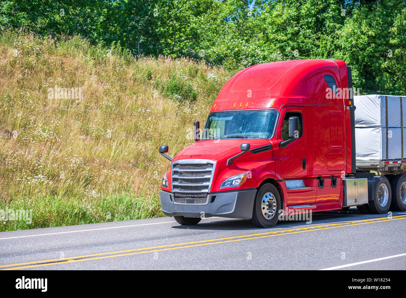 Big rig red classic long haul semi truck with flat bed semi trailer ...
