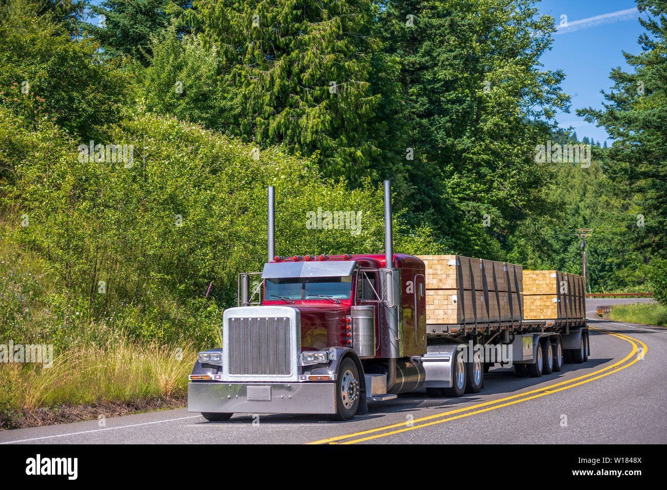 Big rig red classic long haul semi truck with flat bed semi trailer ...