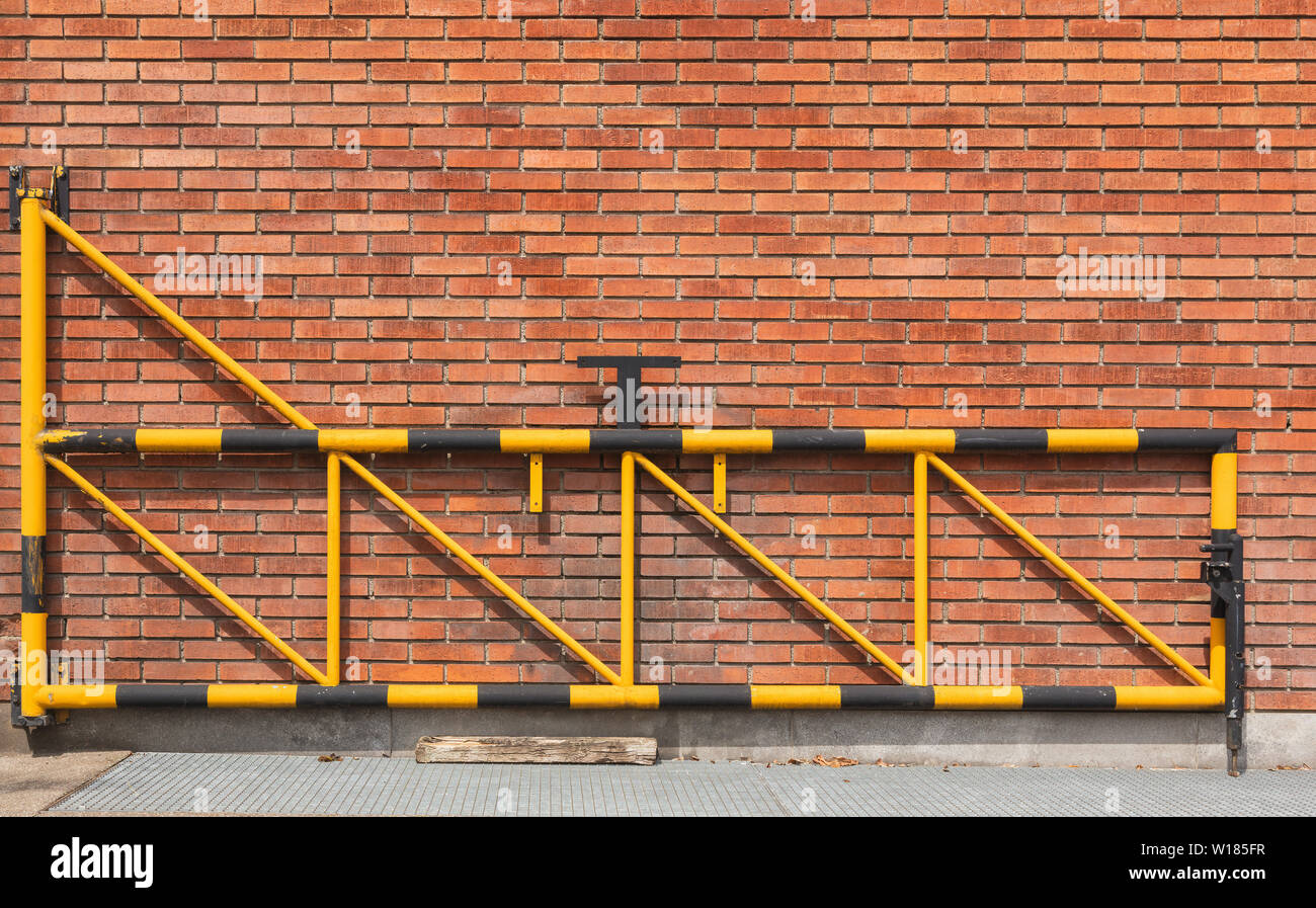 A brick wall of a building and a wing of a gate at it Stock Photo - Alamy