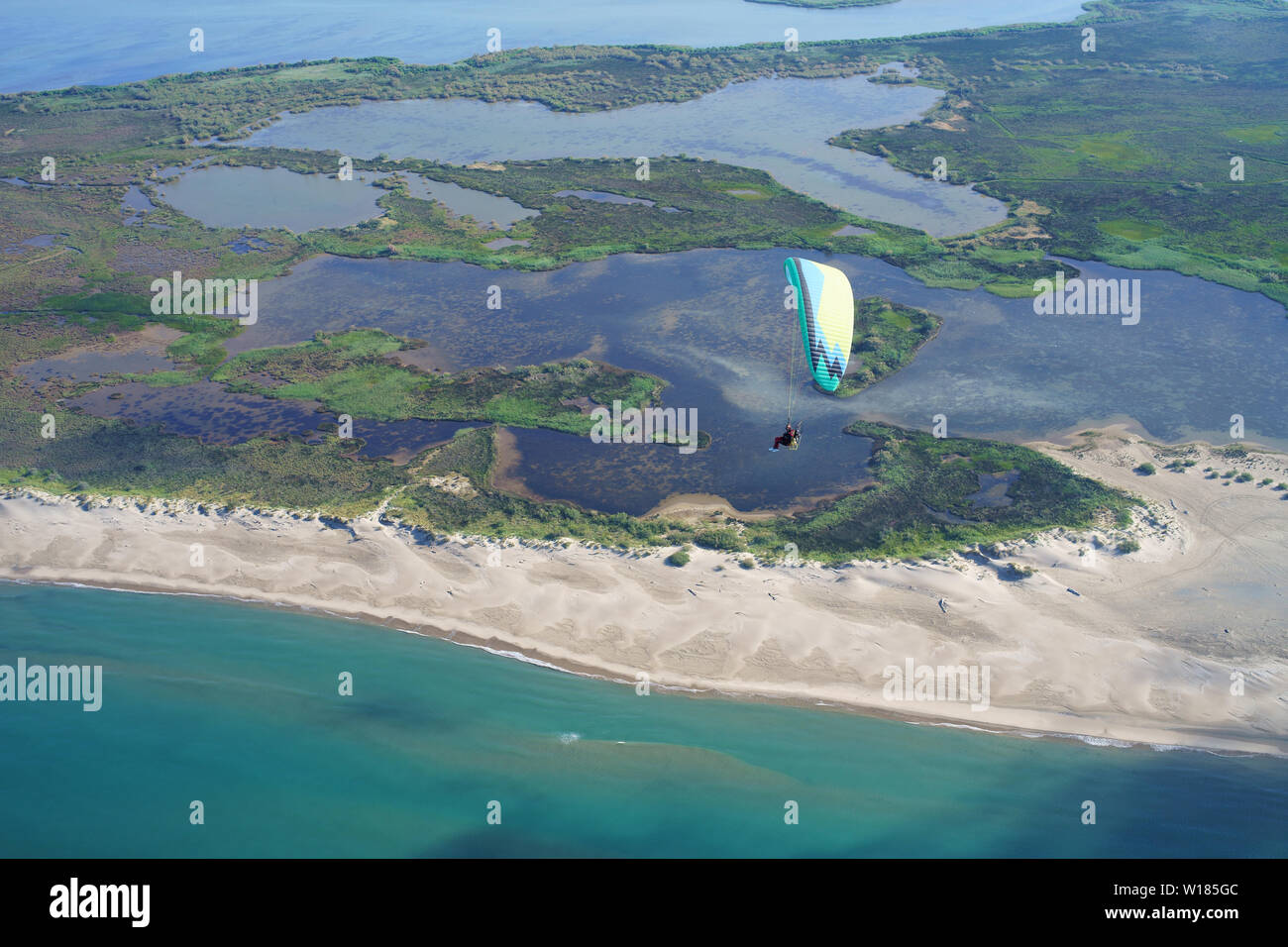 AERIAL VIEW. Paramotorist flying above a landscape of marshlands ...