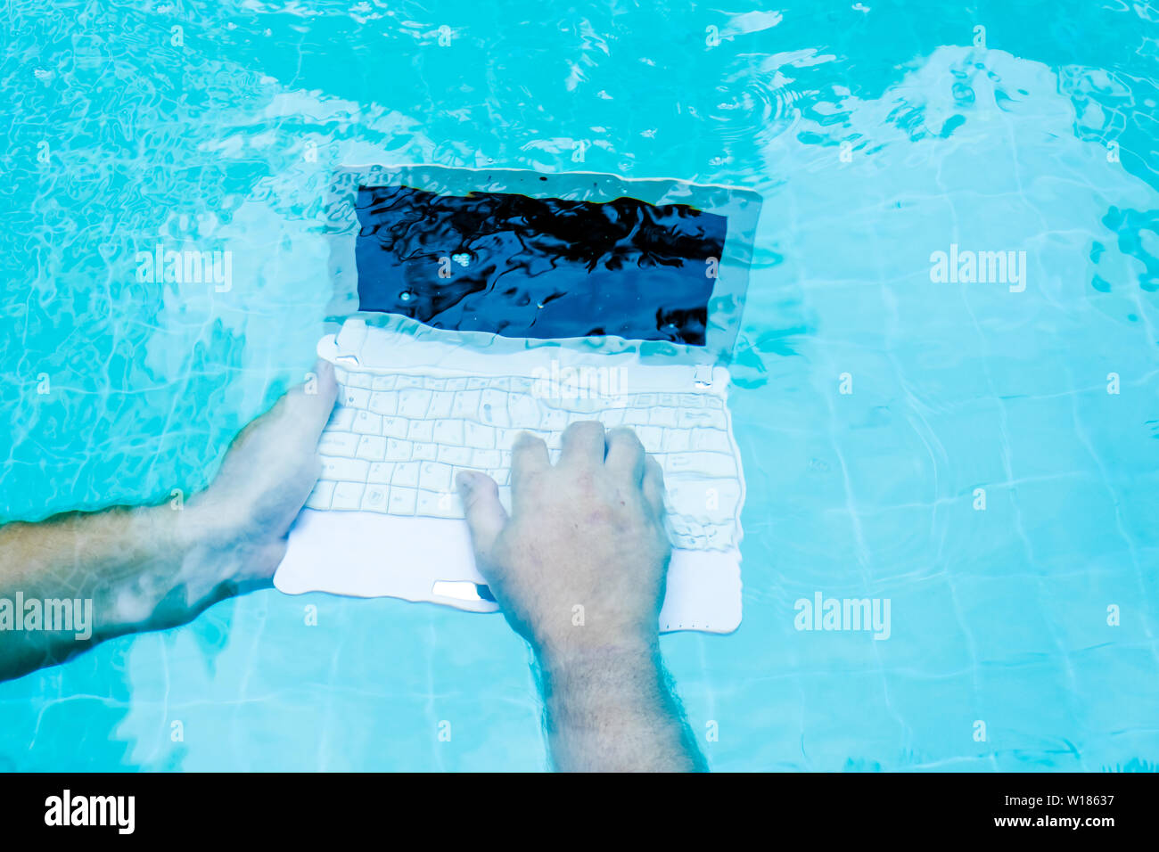 Male hands with a laptop working underwater. The concept of obstruction ...
