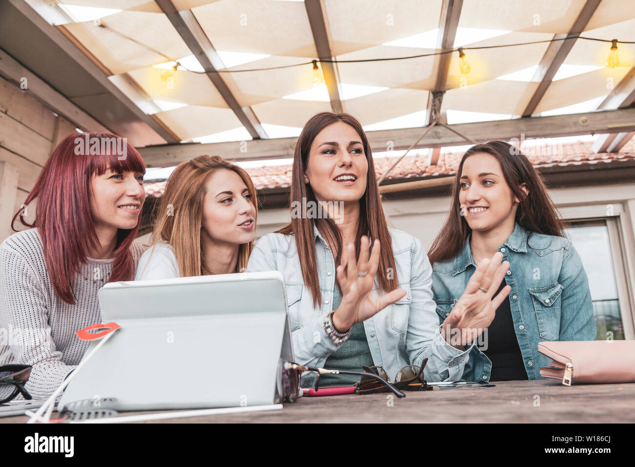four young vloggers talking on the camera leaning against a small ...