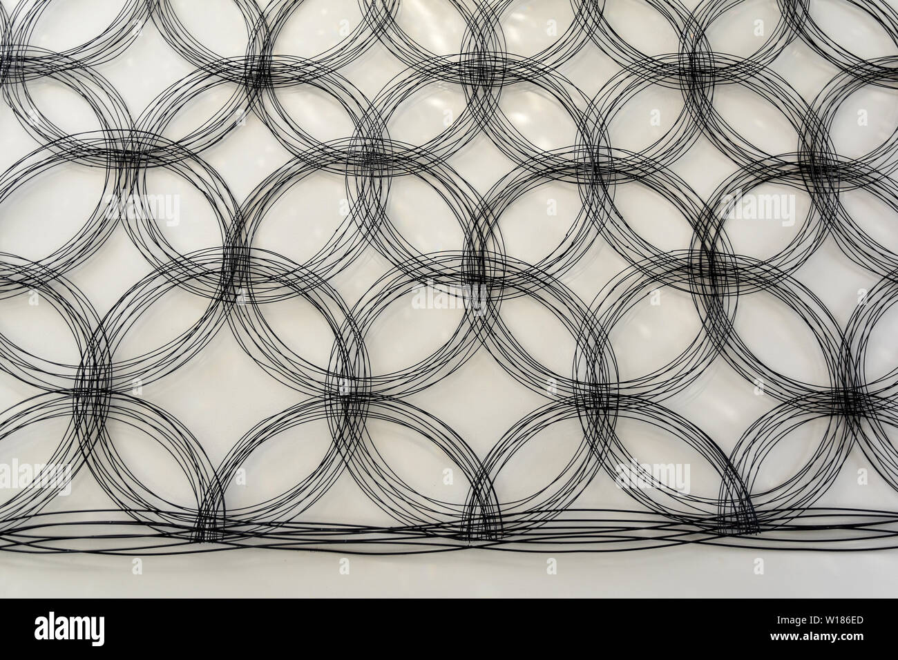 Abstract steel design tri-circle art design against wall. A nice ...