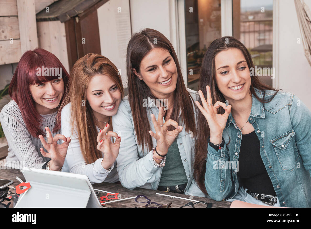 four young vloggers talking on the camera leaning against a small ...