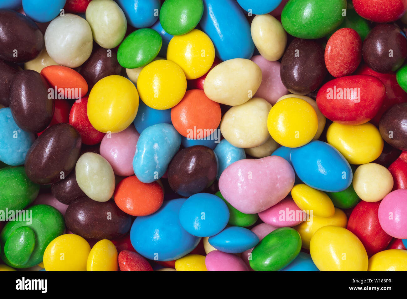 Colorful sweets background. Nuts in multi-colored glaze dragee. Pile of ...