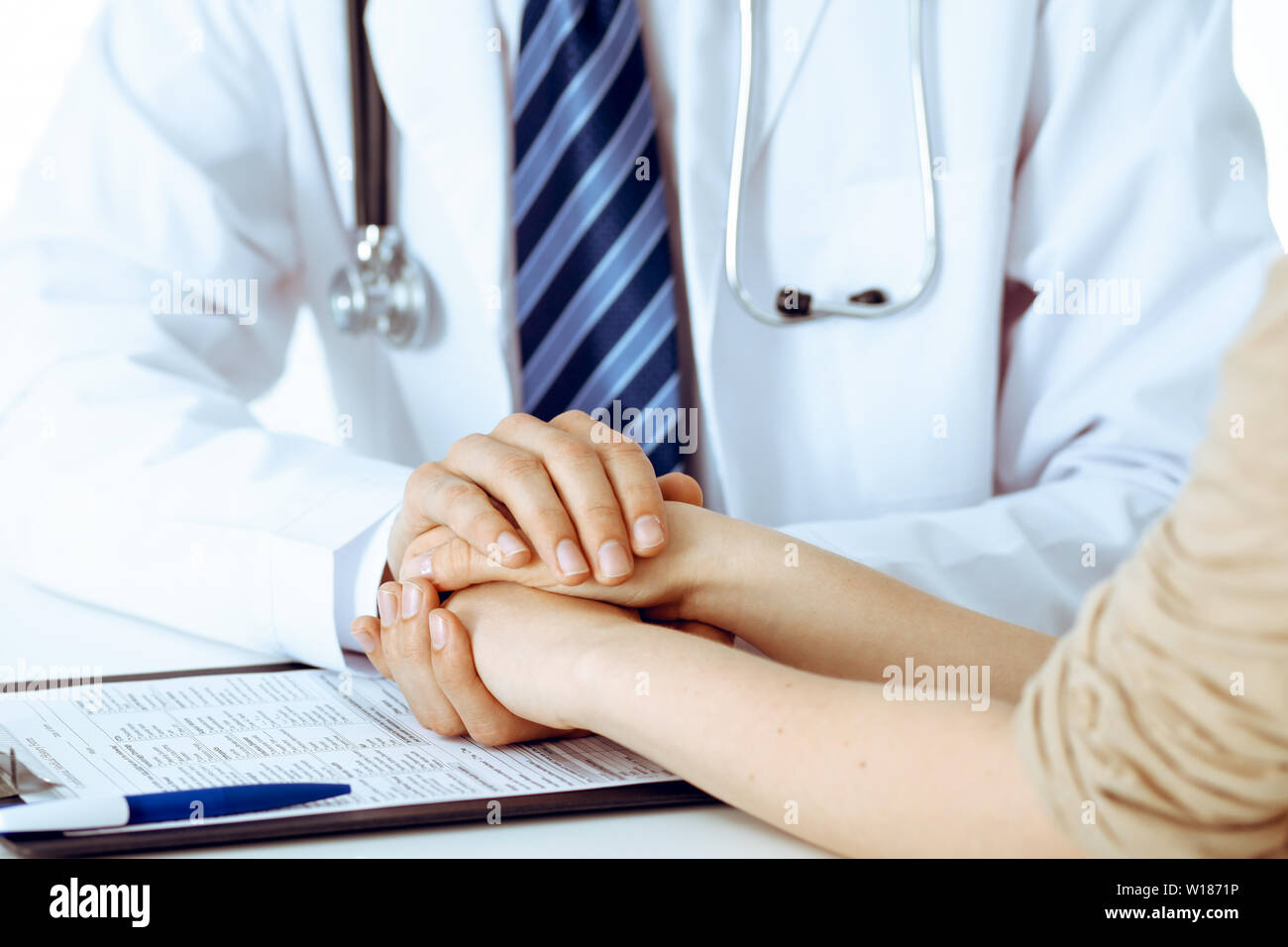 Hand of doctor reassuring her female patient. Concepts of medical ...