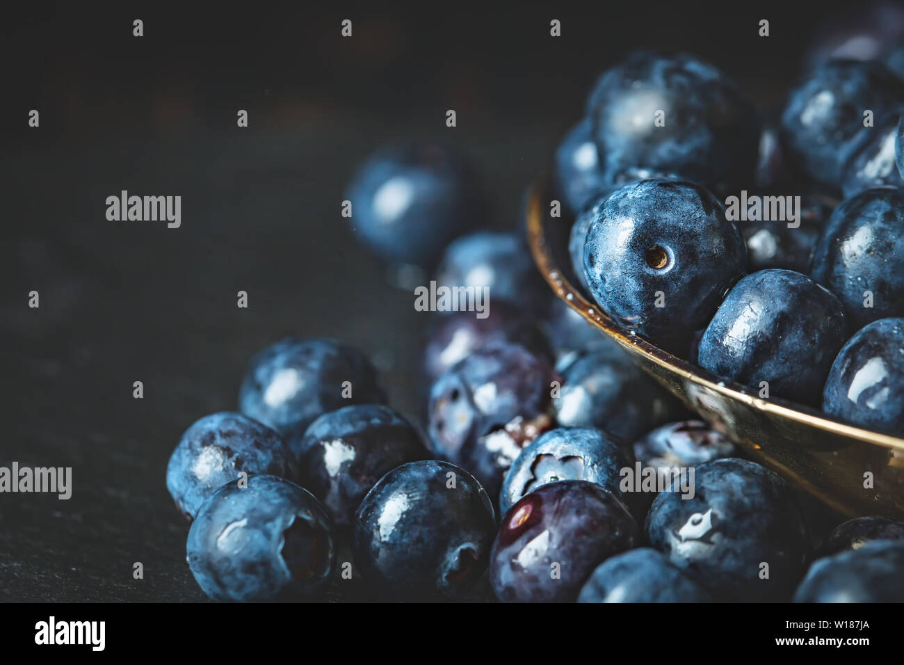 Juicy and fresh blueberries with green leaves on rustic table ...