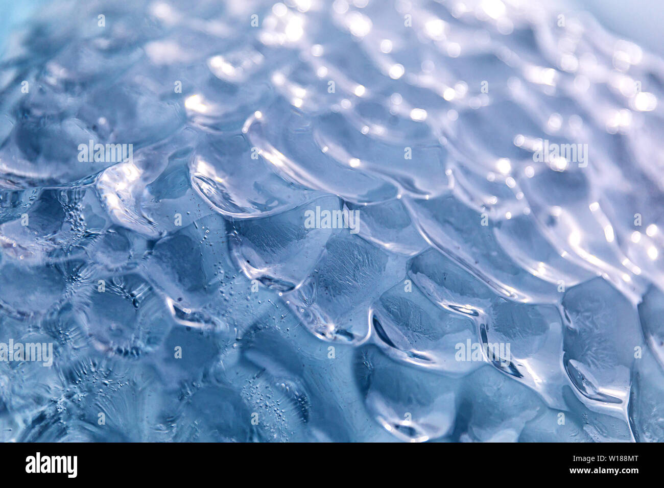 Blue glacial ice closeup. A background of rippled ice which is part of ...